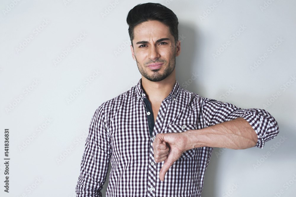 This is bad. Confident young man in unbuttoned shirt looking at a ...
