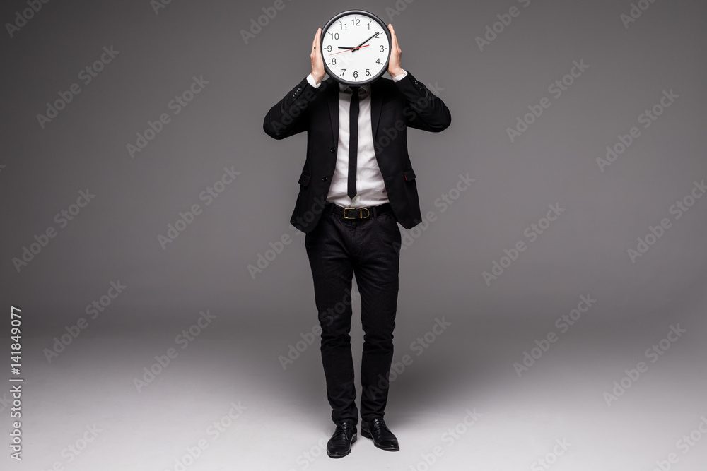 Full height handsome man in gray suit holding big clock covering his ...
