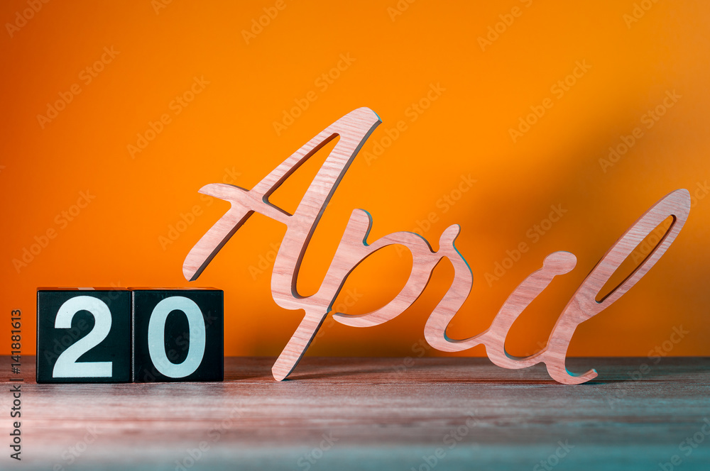April 20th. Day 20 of month, daily wooden calendar on table with orange ...