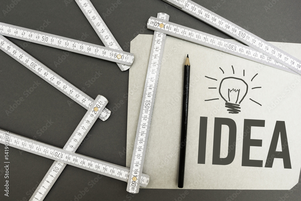 Folding ruler, a blank sheet of paper and a pencil on a gray background ...