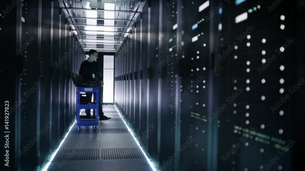 IT Engineer Pushes Crash Cart in the Data Center Corridor with Rows of ...