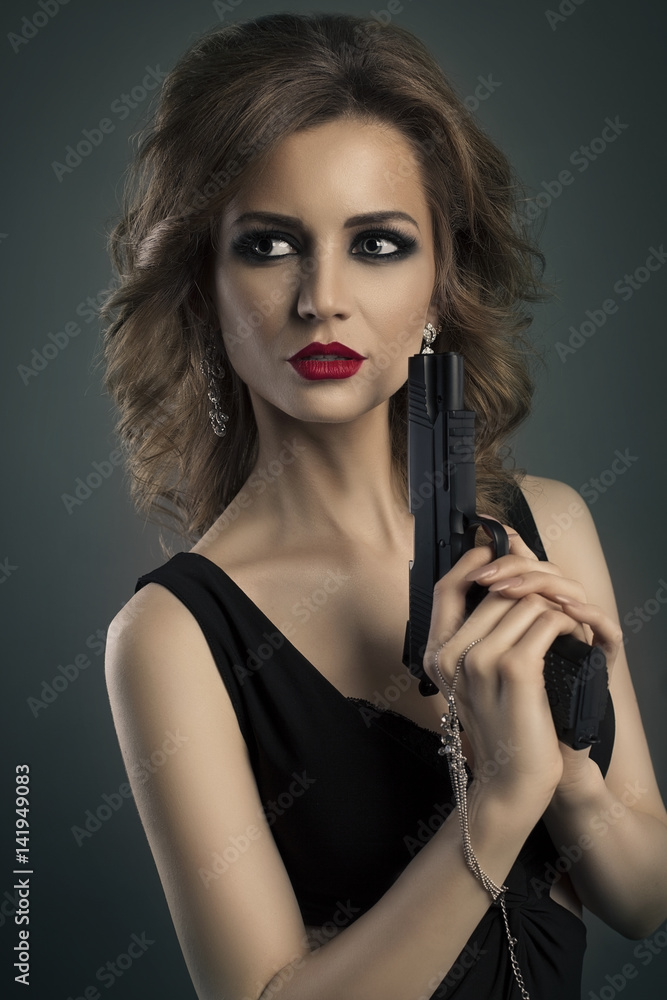 Fashion woman with gun studio shot Stock Photo | Adobe Stock