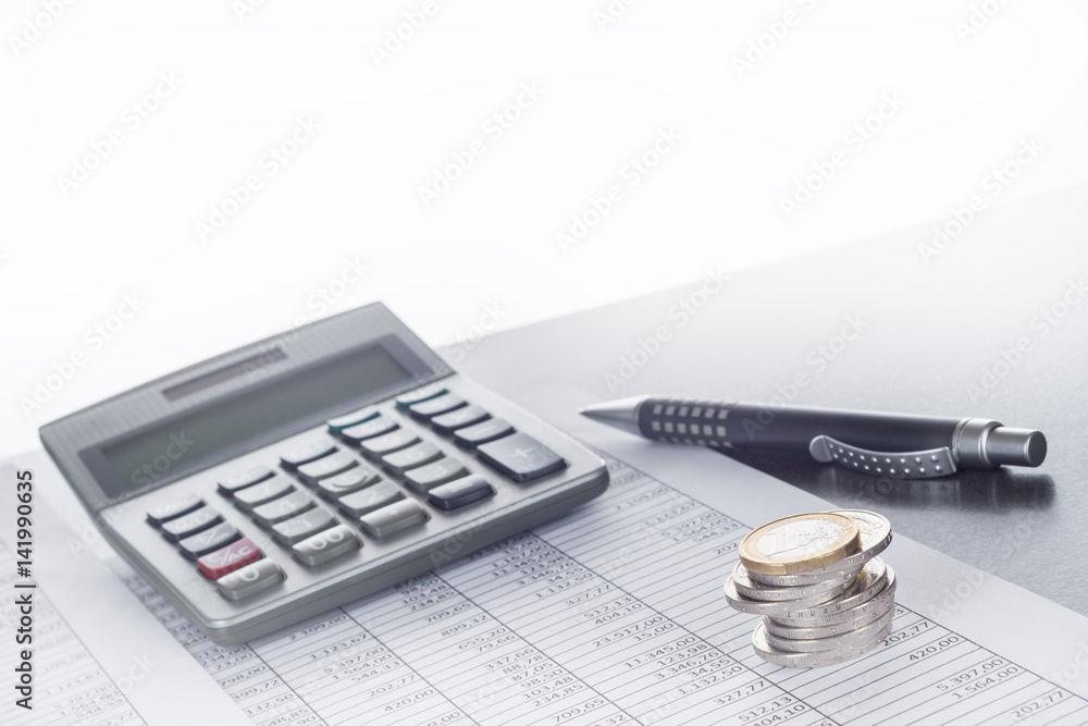 Euromünzen im Stapel, Stift und Taschenrechner auf Tabellen ...