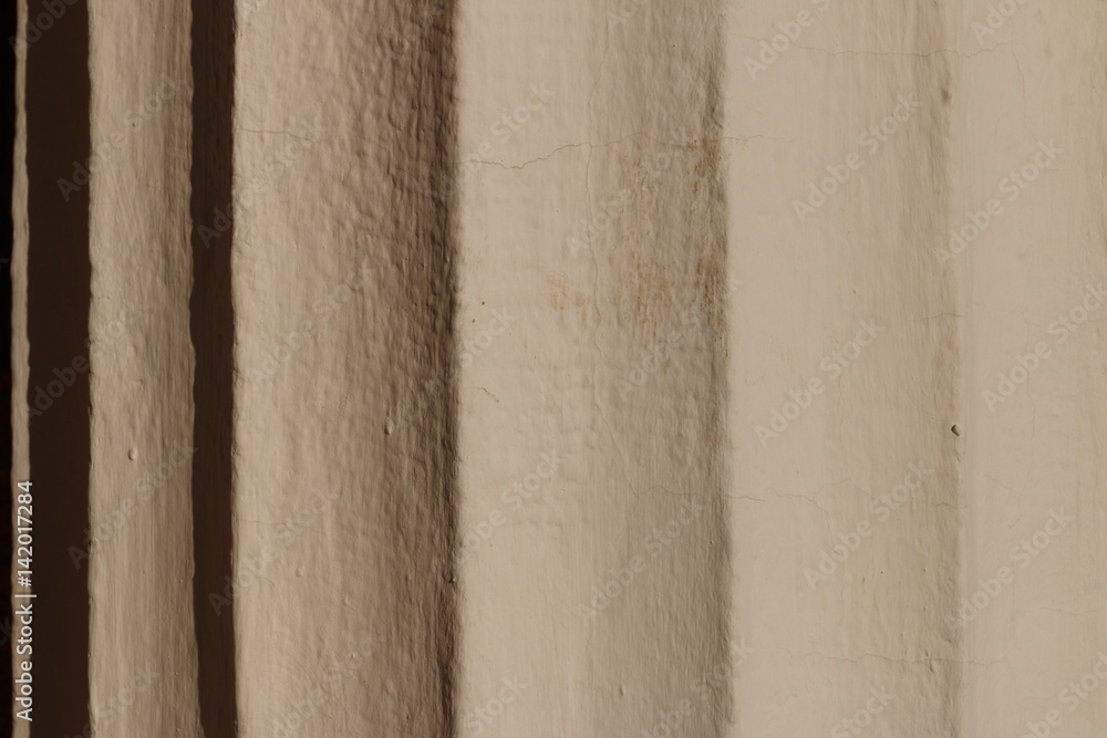 Fragment of the column with flutes. Bright sun reveals details ...