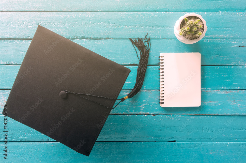 graduation cap, hat on blue wood table with Empty notebook view from ...