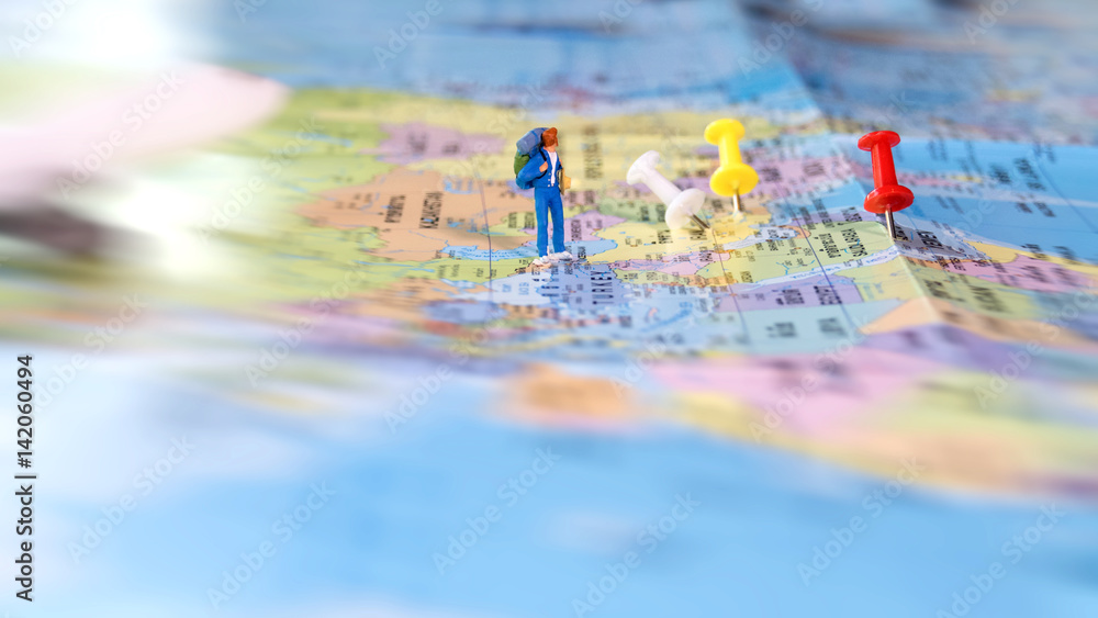 Traveler miniature mini figure with backpack walk on world map with pin ...