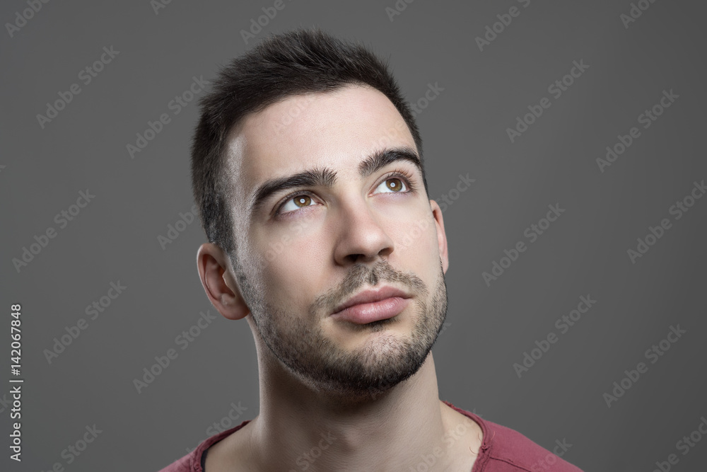 Close up of young handsome man face looking up thinking. Atmospheric ...