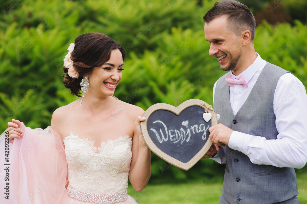 Romantic couple holding heart outdoors. The bride and groom holding ...
