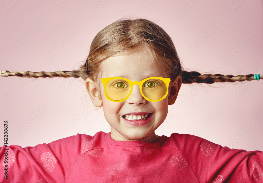 Pretty happy girl in drawn yellow spectacles over pink background ...