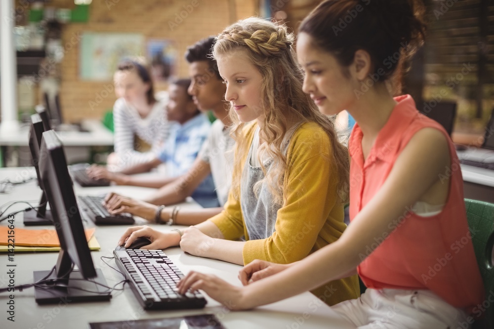 Smiling students studying in computer classroom Stock Photo | Adobe Stock