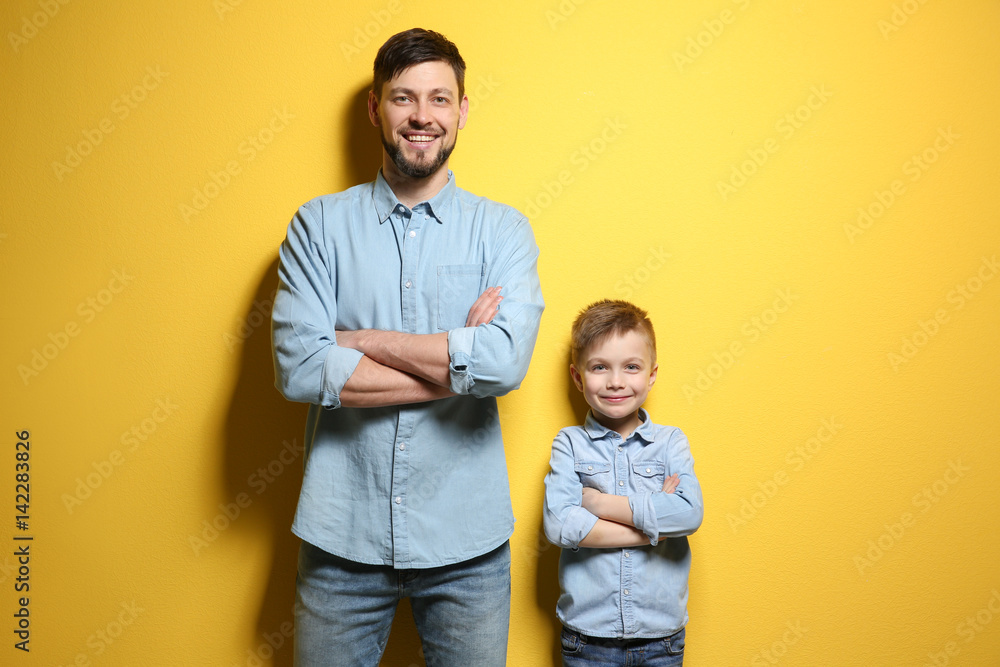 Handsome man with his son on color background Stock Photo | Adobe Stock