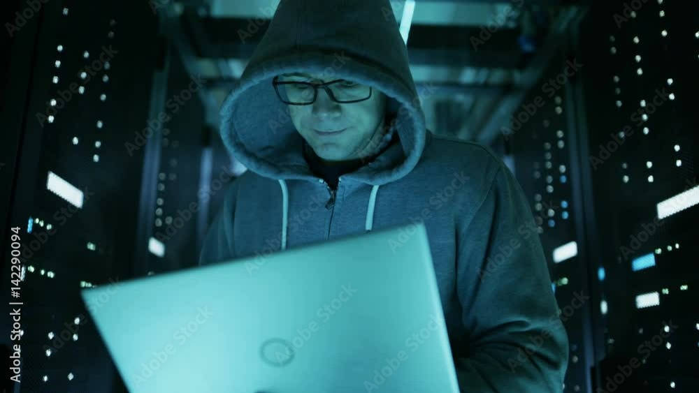Low Angle Shot of Computer Hacker in Hoodie, Holding Laptop. He Breaked ...