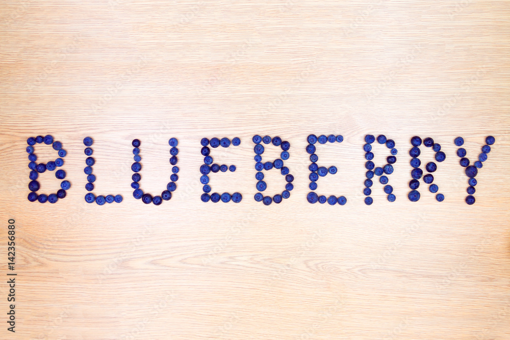 Healthy food. Word "blueberry" made of berries isolated on beige ...