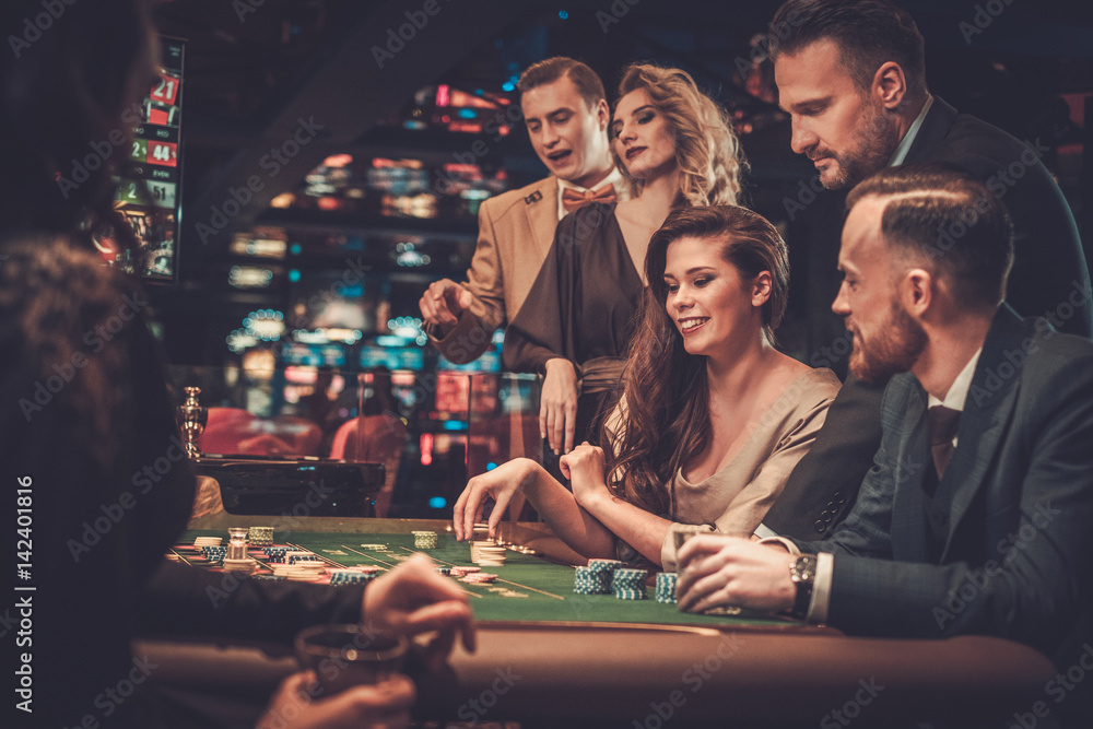 Upper class friends gambling in a casino Stock Photo | Adobe Stock