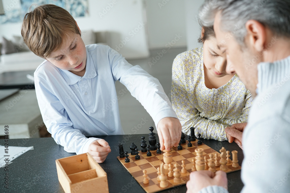 Family playing chess game at home Stock Photo | Adobe Stock