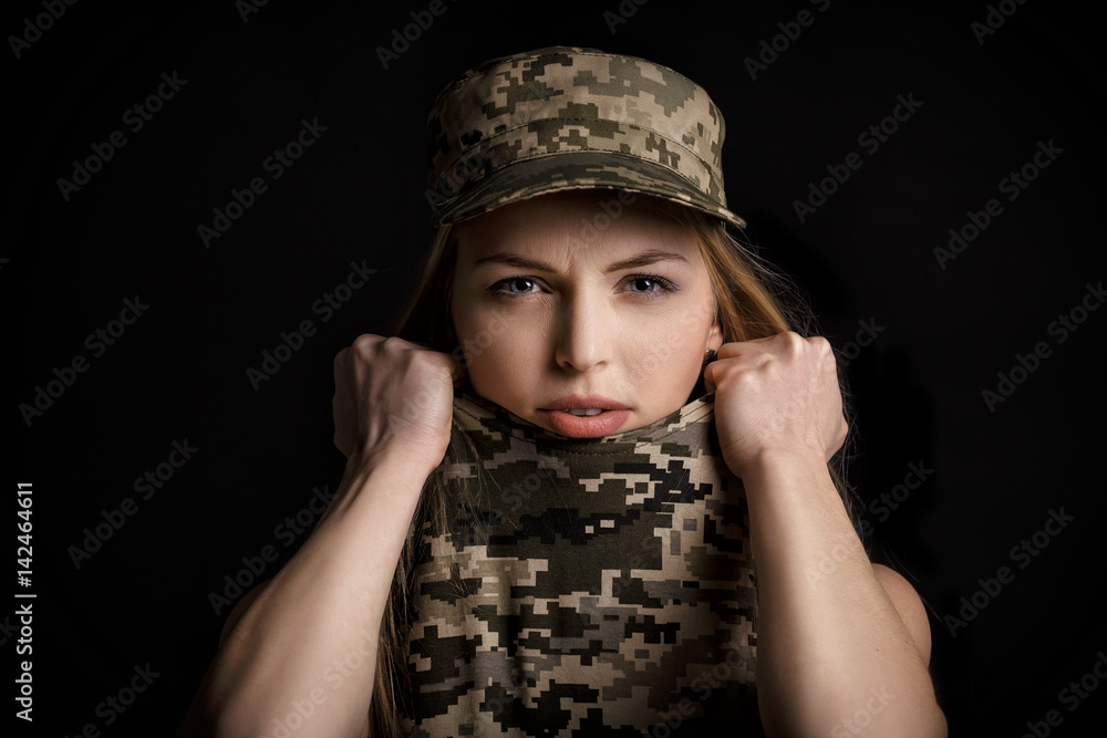 portrait of scared woman soldiers in military attire on black ...