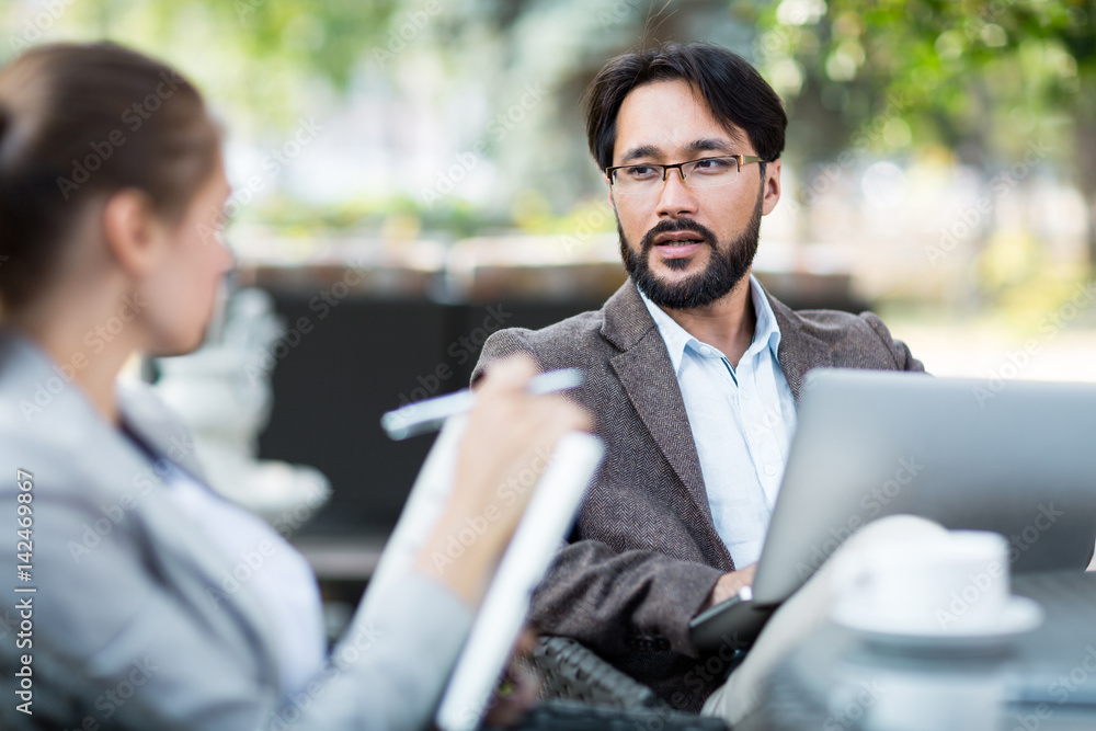 Asian HR manager conducting interview with female applicant for ...