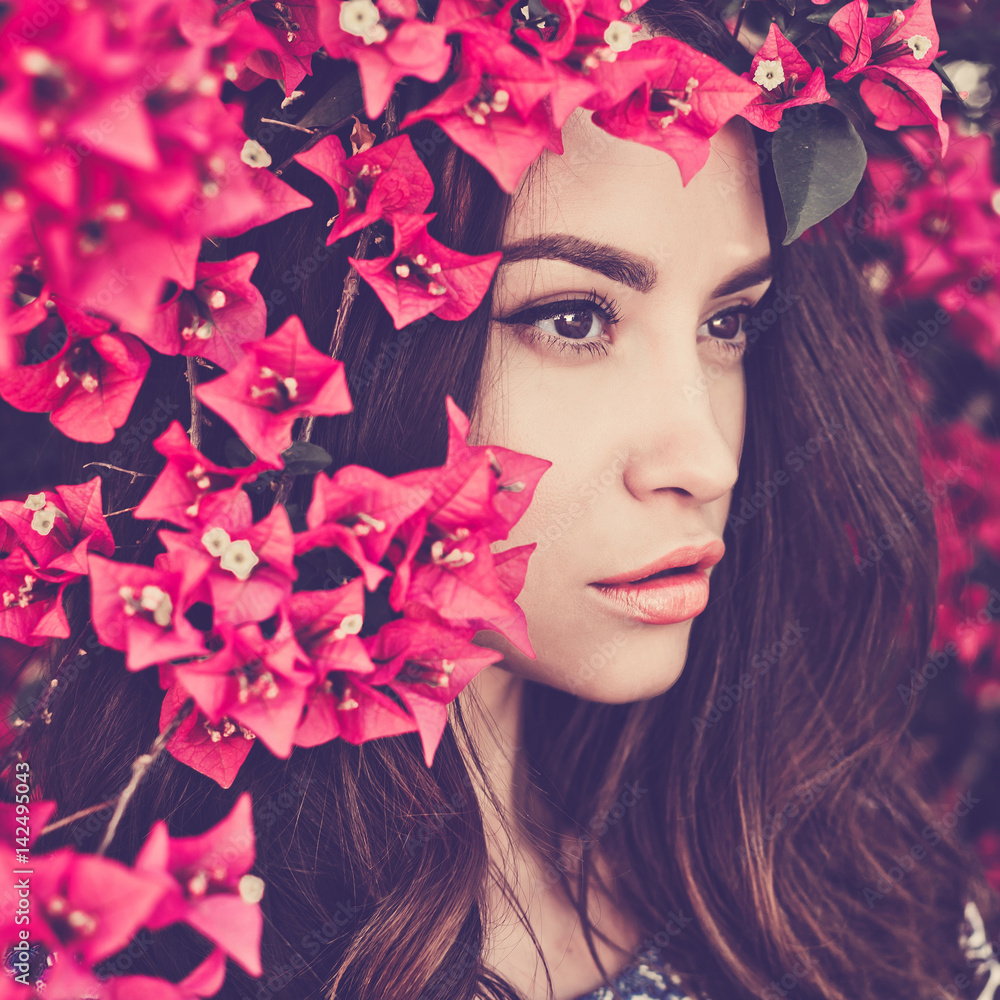 Beautiful young woman surrounded by flowers Stock Photo | Adobe Stock