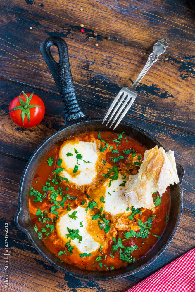 Traditional Arabic dish shakshuka in a black cast iron pan on the ...