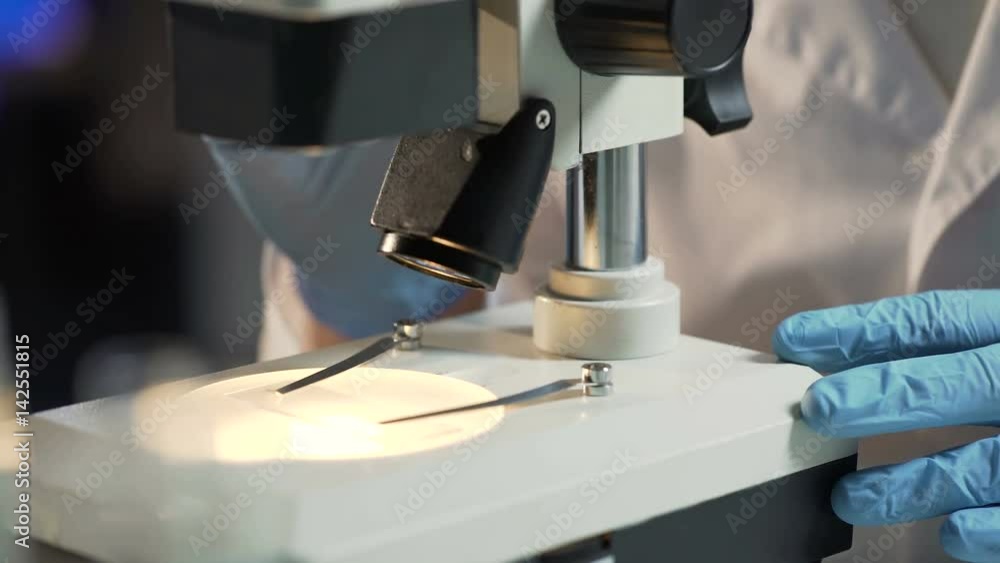Laboratory worker examining abnormal structure of cells under ...