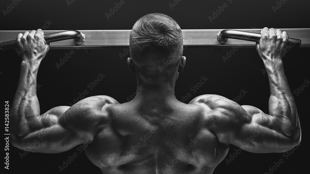 Close-up photo of attractive muscular bodybuilder guy doing pullups in ...