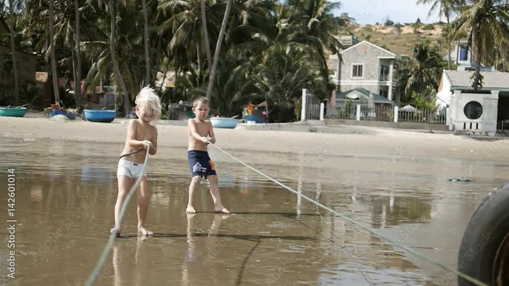 Vidéo Stock Cute adorable happy children having fun on the sand beach ...