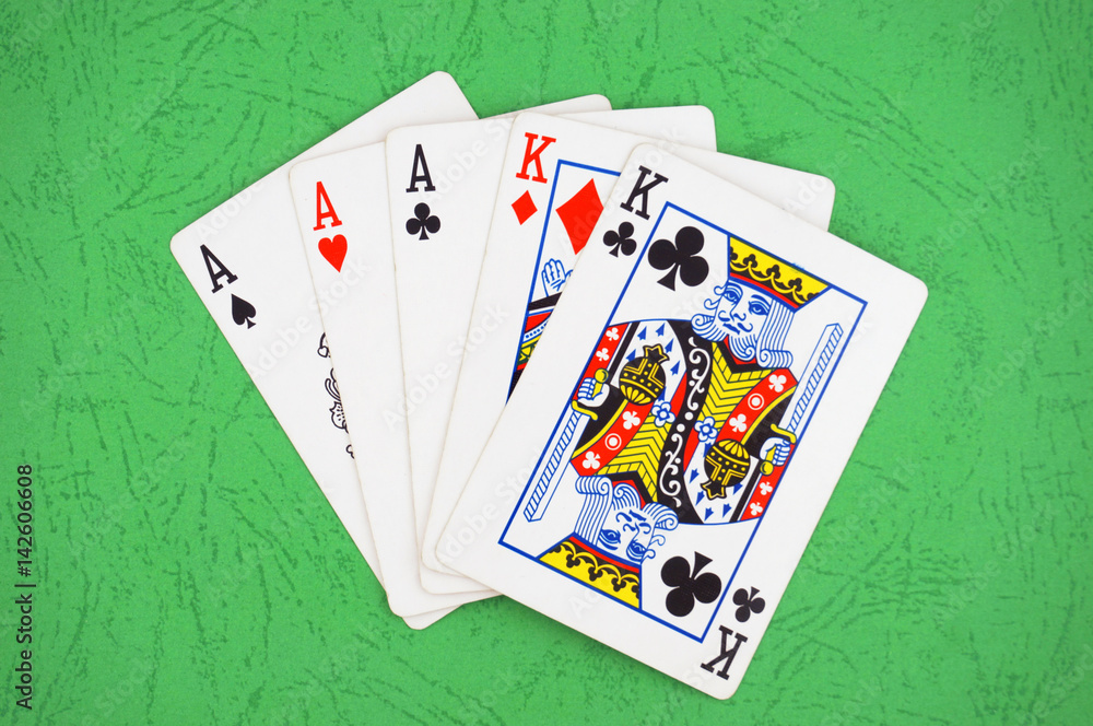 Full house. Three aces, two kings. Maps on the green table foto de ...