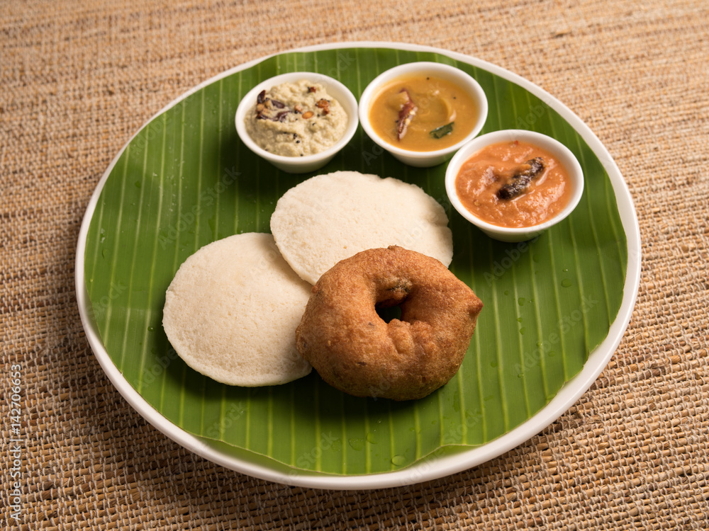 idli with vadai sambar coconut chutney and kara chutney served in a ...