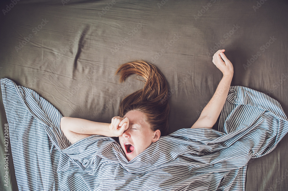 Beautiful young woman lying down in bed and sleeping, top view. Do not ...