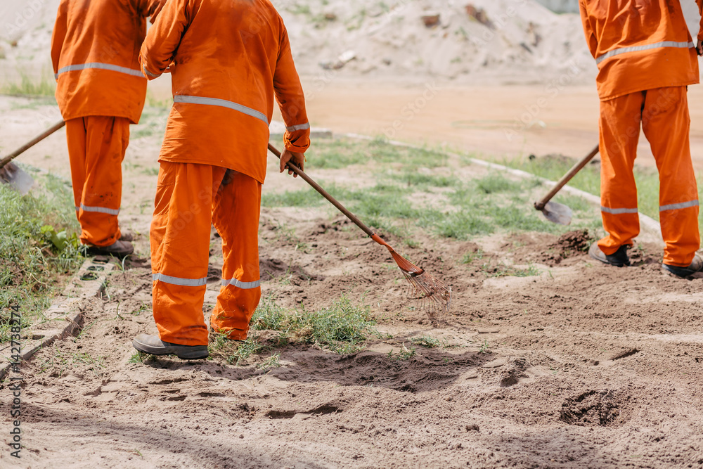 Workers using hoe to remove weeds. Construction of sidewalks Stock ...