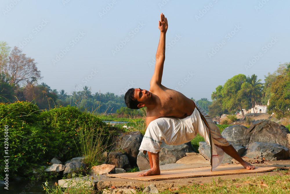 An Indian yogi performing yoga asanas on a riverbank in India. Stock ...