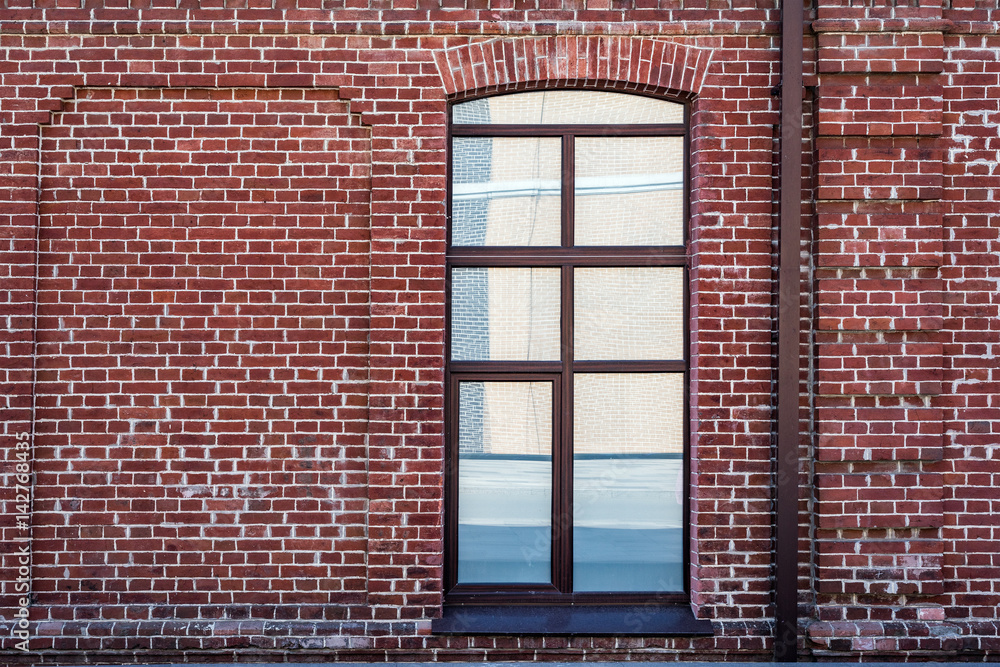 Urban design. Brick wall of an old house with a window. Reflection of a ...