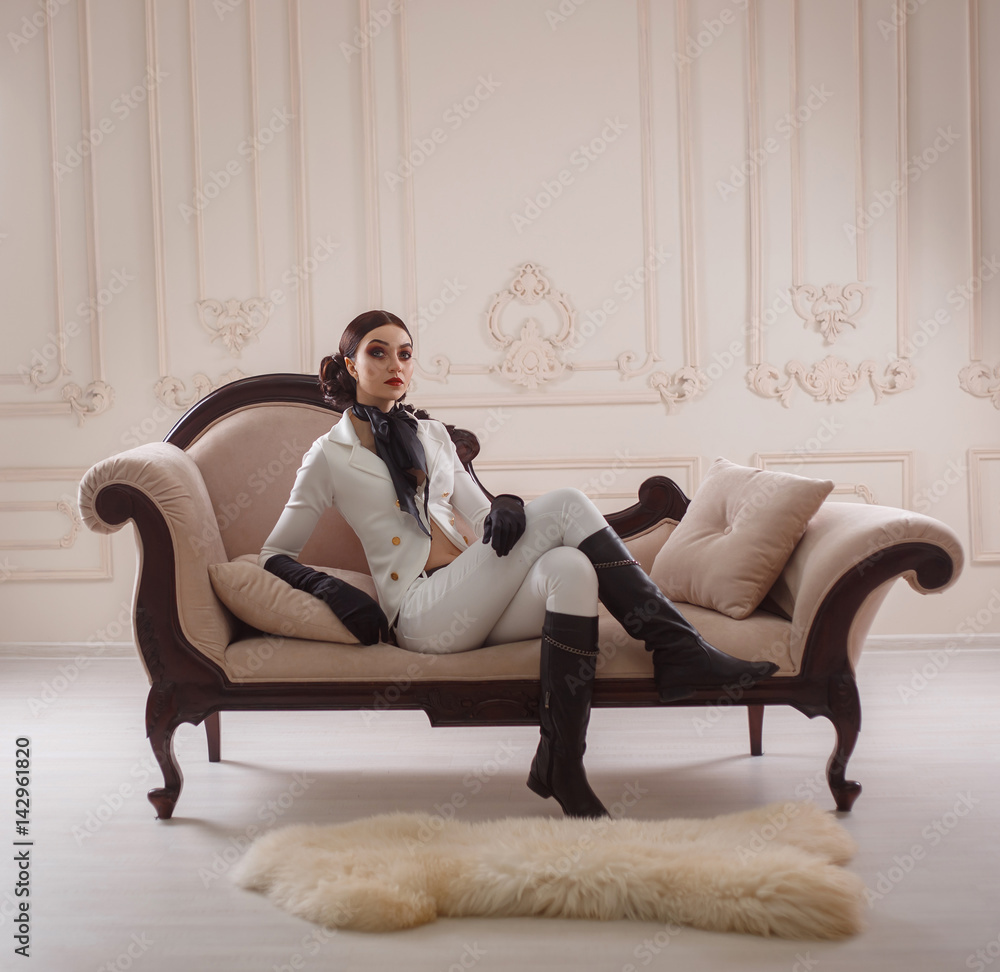 Strict, beautiful girl in elegant rider suit poses on camera ...