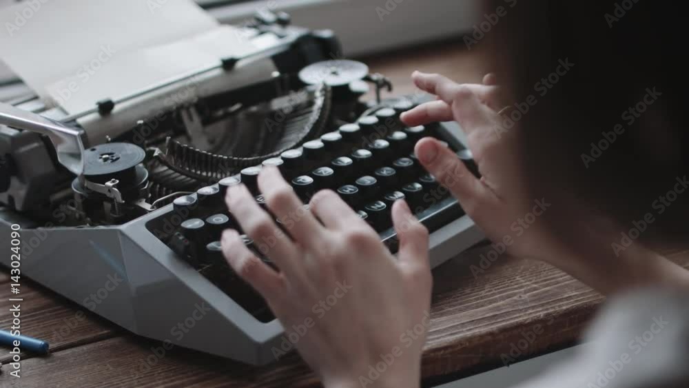 Writer typing with retro writing machine. View from over shoulder ...