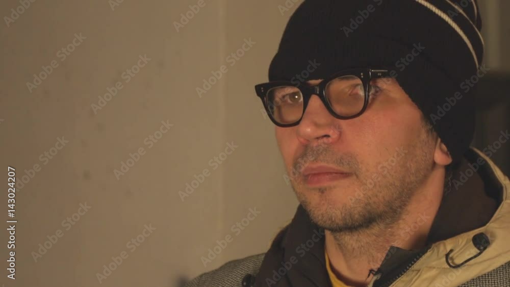 Face of a man close-up against a wall background. Suspicious man in a ...