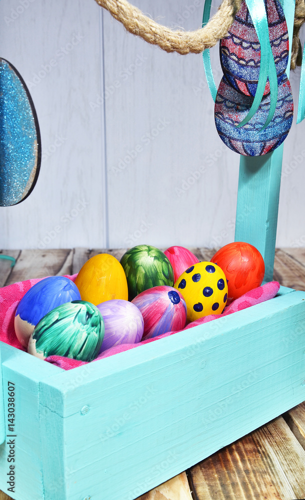 Bright Easter eggs in a colored basket. Testicles in a wooden box. The ...