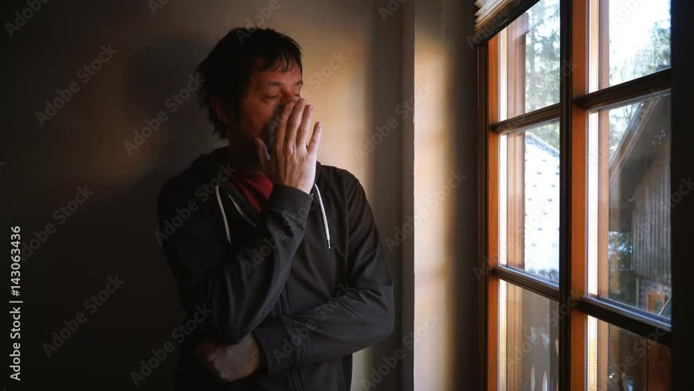 Sad and hopeless man thinking by the bedroom window, low key portrait ...