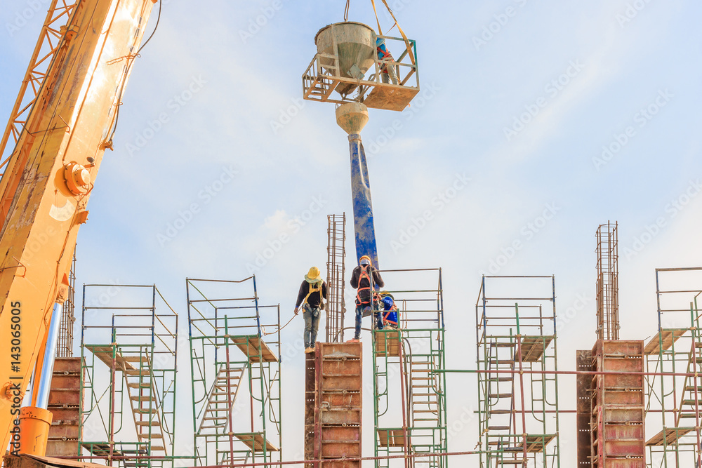 Construction workers working on scaffolding at a high level by the ...