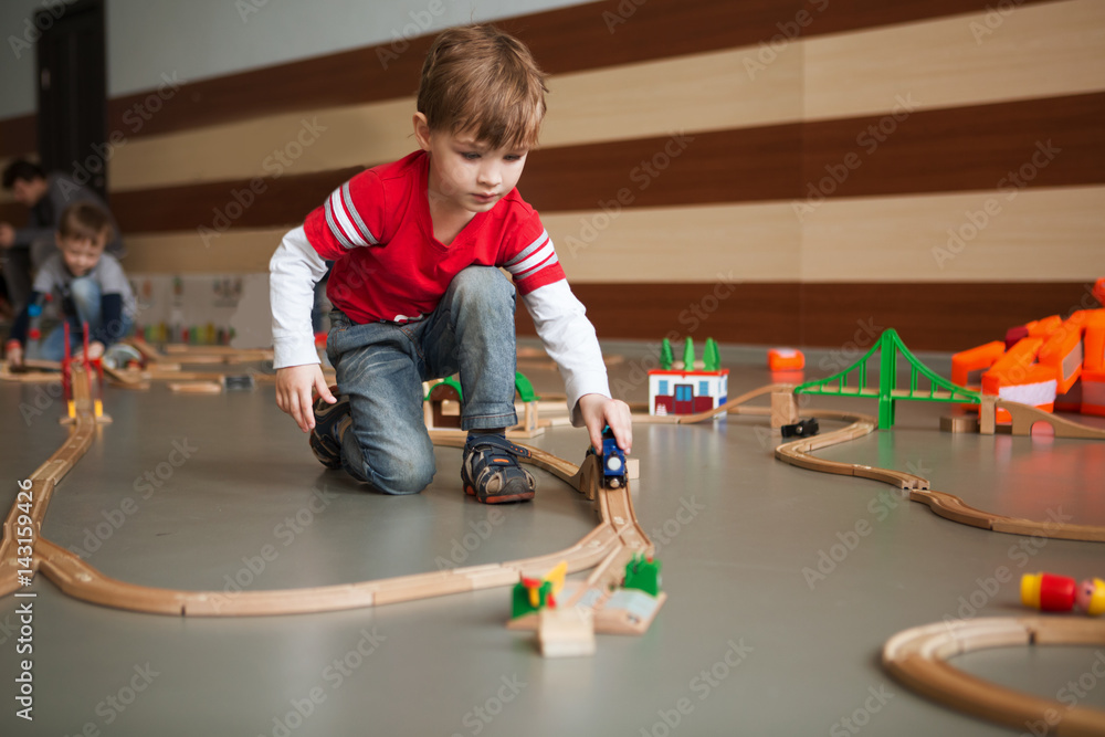 Child boy play with wooden train, build toy railroad or daycare. Stock ...