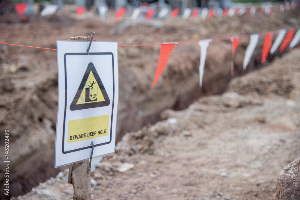 Beware deep hole warning sign and white red flag safety in construction ...