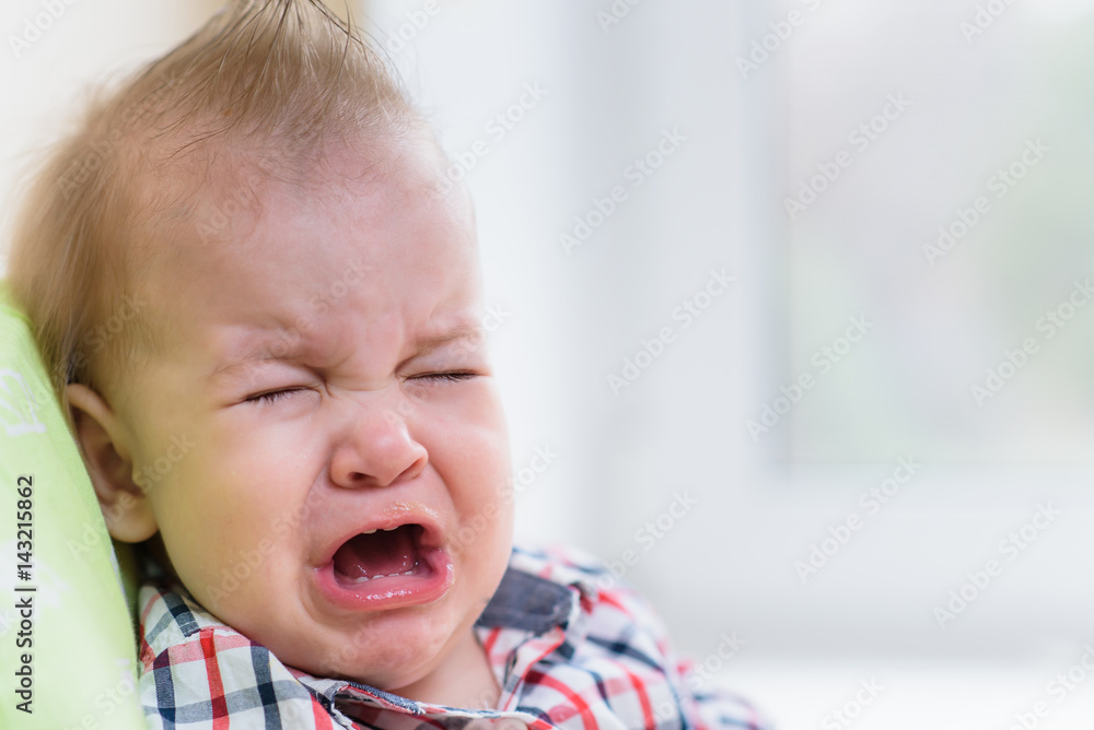 Baby crying sitting on a chair at home Stock Photo | Adobe Stock