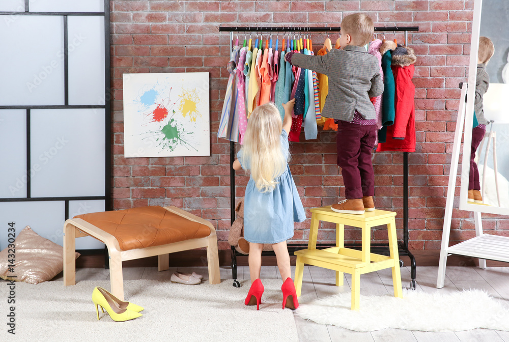 Cute little children choosing clothes in dressing room Stock Photo ...