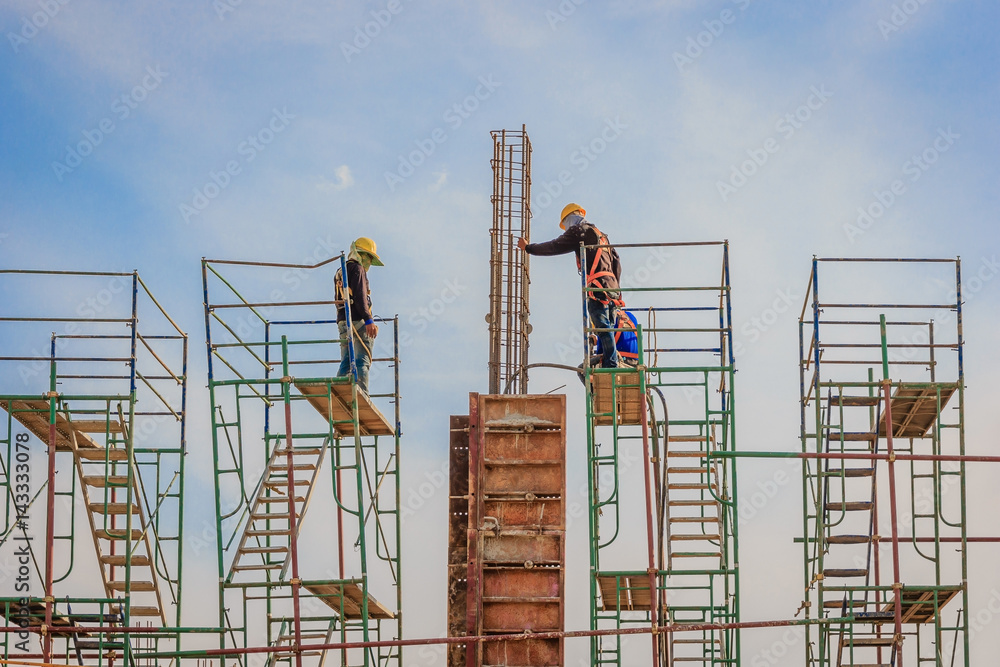 Construction workers working on scaffolding at a high level by the ...