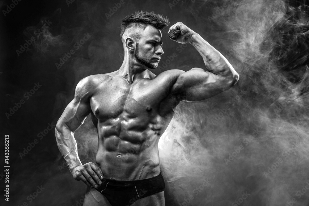 Handsome power athletic man bodybuilder. Fitness muscular body on dark ...