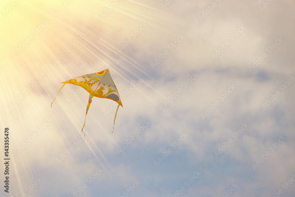 Colorful kite flying high in the blue sky with sunlight Stock Photo ...