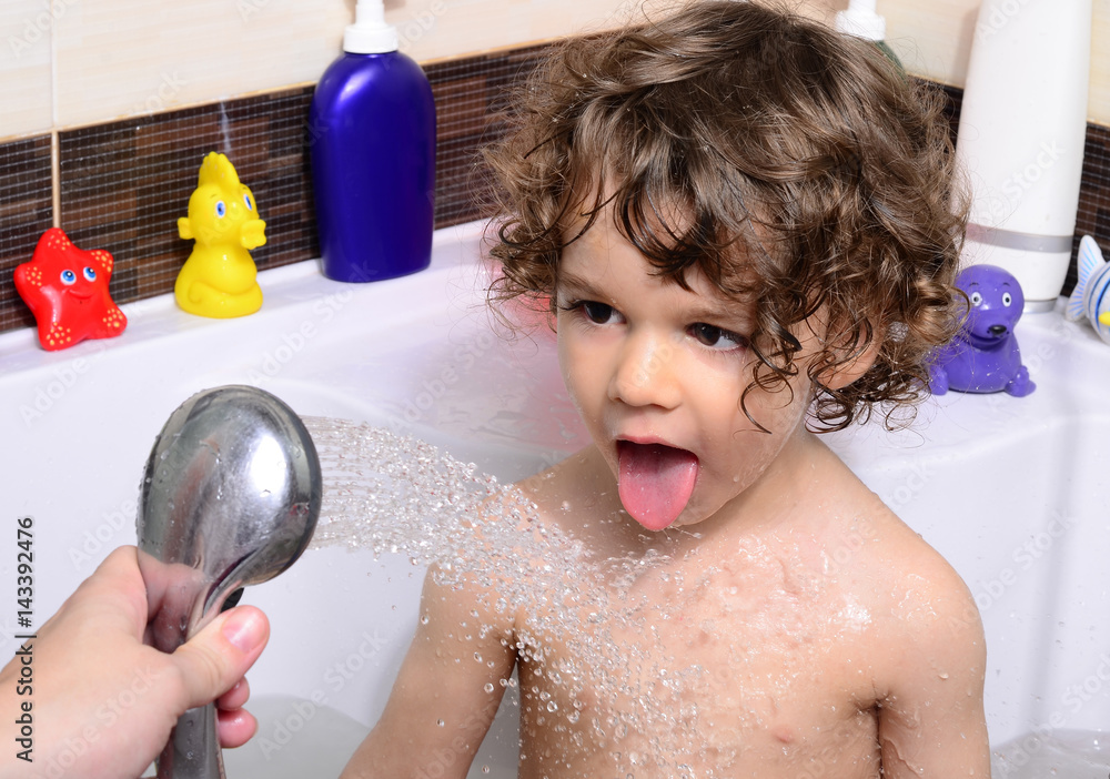 Beautiful toddler taking a bath in a bathtub with bubbles. Cute kid ...