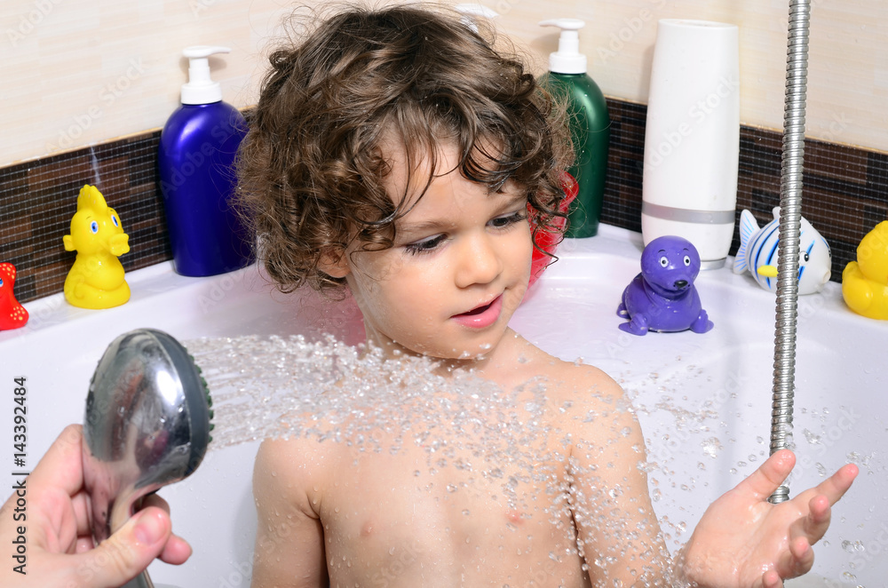 Beautiful toddler taking a bath in a bathtub with bubbles. Cute kid ...