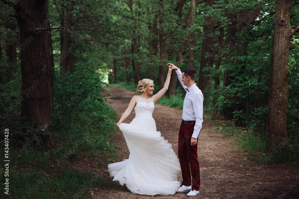 Happy and young bride and groom dancing on nature, dance pose on ...