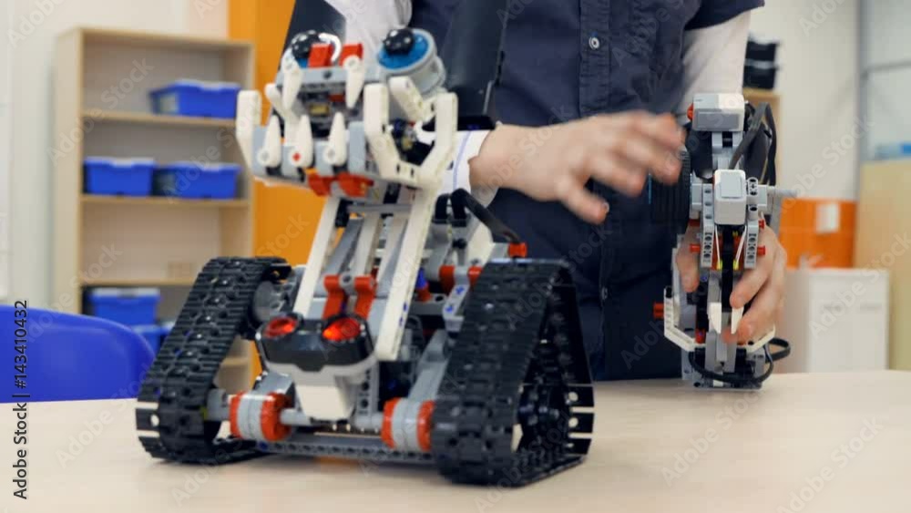 Student boy testing robot in robotechnics school classroom. Engineer ...