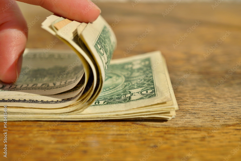 Male hand checking and counting a heap of American money (US currency ...